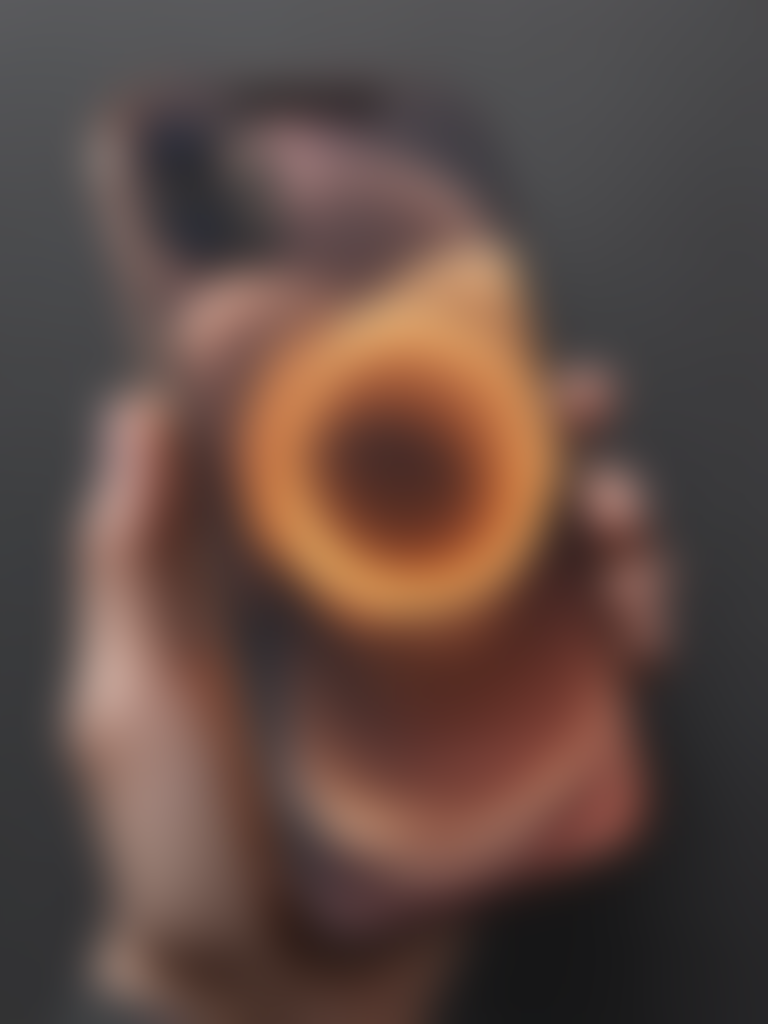 Hand Holding a Phone with a Unique Circular Case Design in Focus