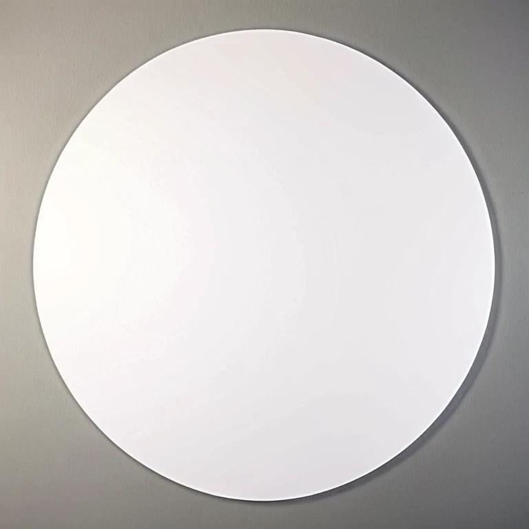 Minimalist Round Mirror Reflecting Light Against a Simple Gray Wall