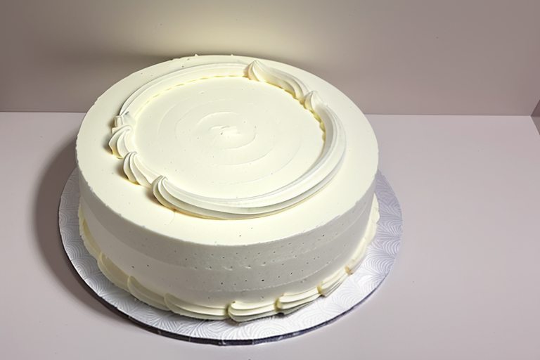 A Beautifully Decorated White Cake with Elegant Swirls and Smooth Frosting.