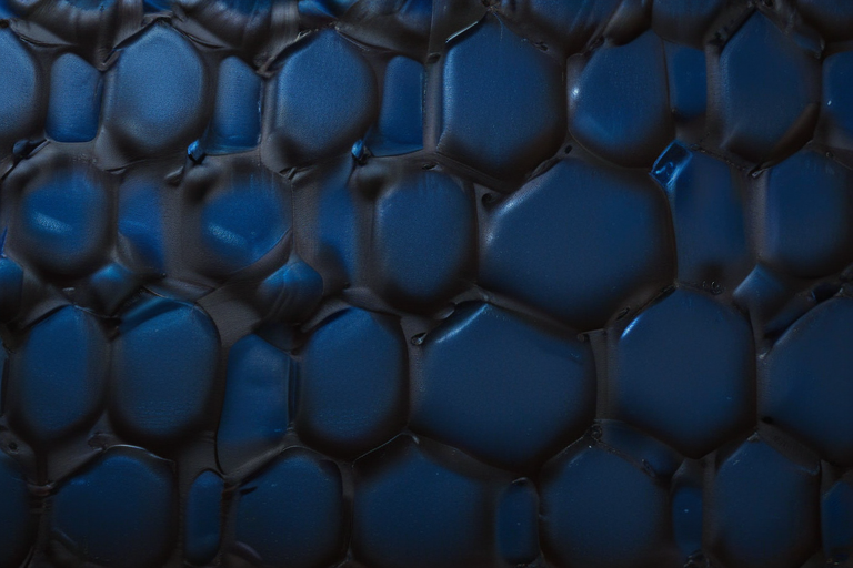 Close-Up View of Dark Blue Textured Surface with Bubble-Like Patterns