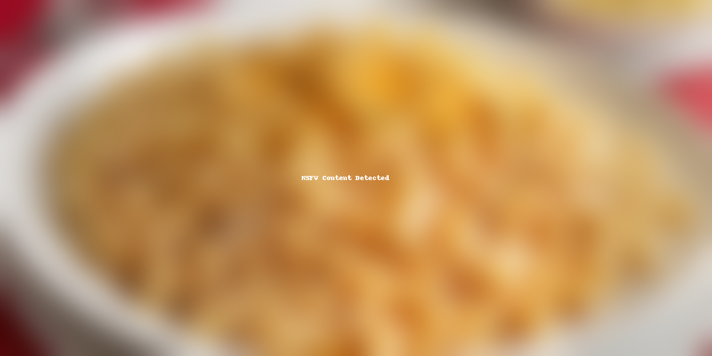 Deliciously Cheesy Pasta Dish Served in a White Bowl on a Table.