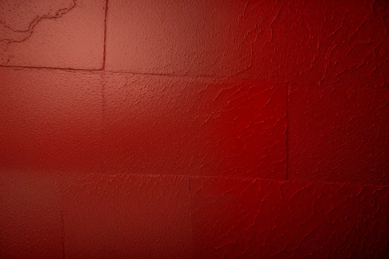 Textured Red Wall Surface with Subtle Variations in Light and Shadow