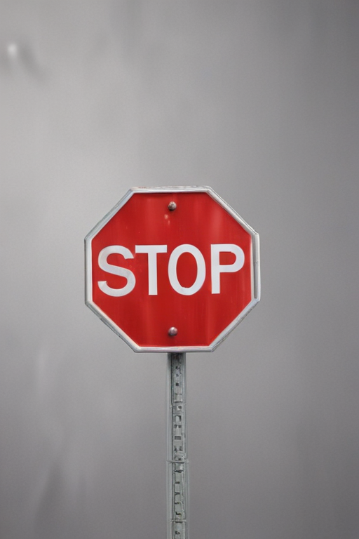 A Bold Red Stop Sign Standing Against a Neutral Background for Traffic ...