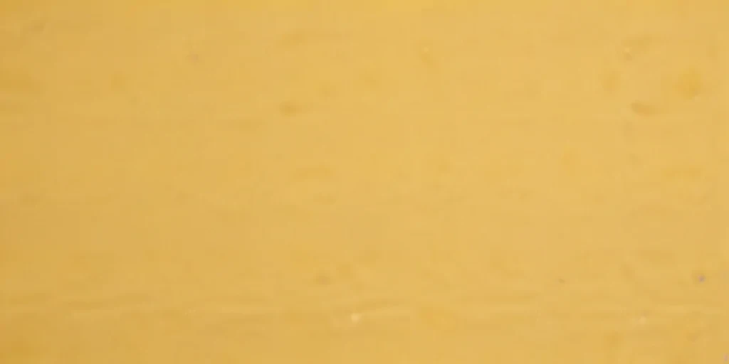 A Close-Up View of Smooth, Vibrant Yellow Texture with Subtle Patterns.