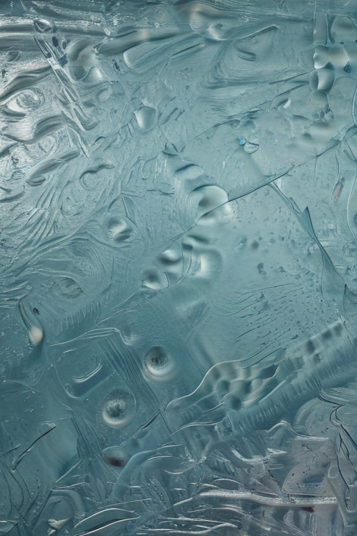 Intricate Patterns of Frosted Glass Reflecting Light in Cool Tones