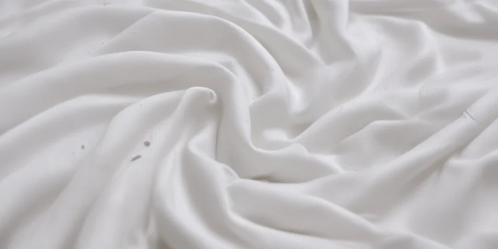 Soft and Flowing White Fabric with Gentle Creases and Textured Surface