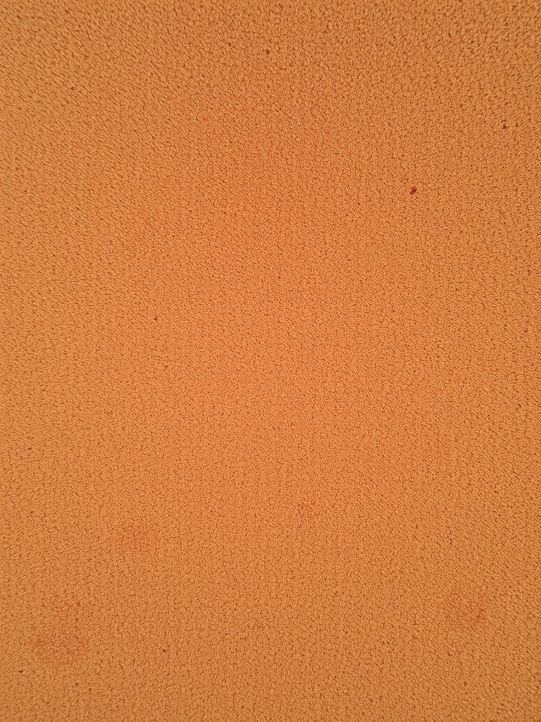 Textured Surface of Soft Orange Foam Material with Fine Details.