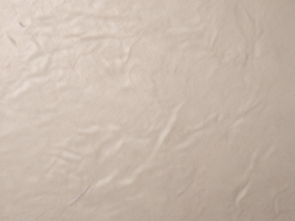 Textured Surface of Soft Beige Material with Subtle Waves and Creases.
